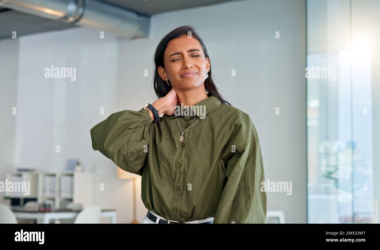 Businesswoman suffering from neck pain and discomfort caused by stress ...