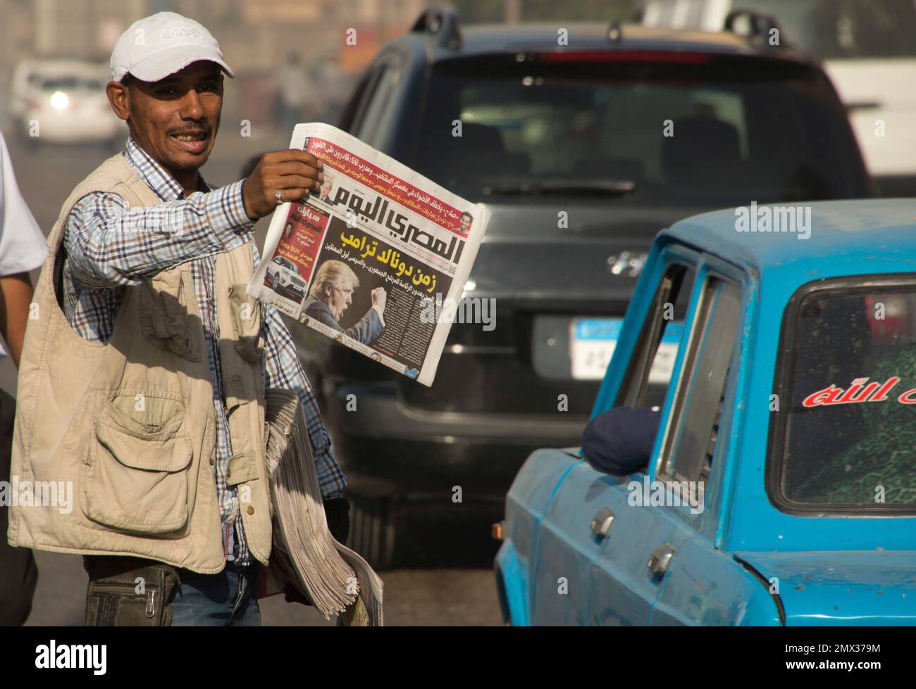 An Egyptian newspaper vendor holds copies of local newspapers fronted ...