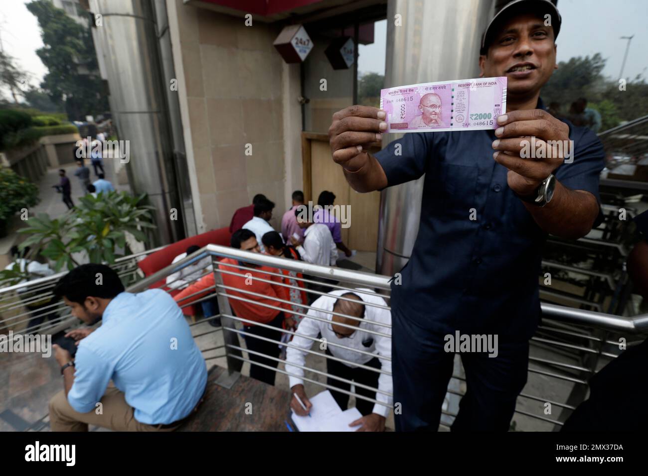 A man displays a new Indian currency note of denomination 2000 that he ...