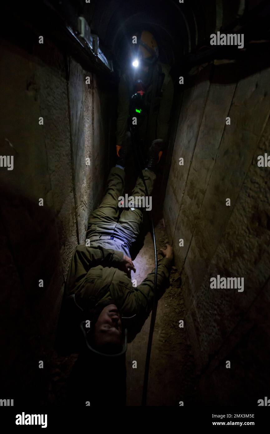 An Israeli soldier from the Home Front Command hold the legs of a ...