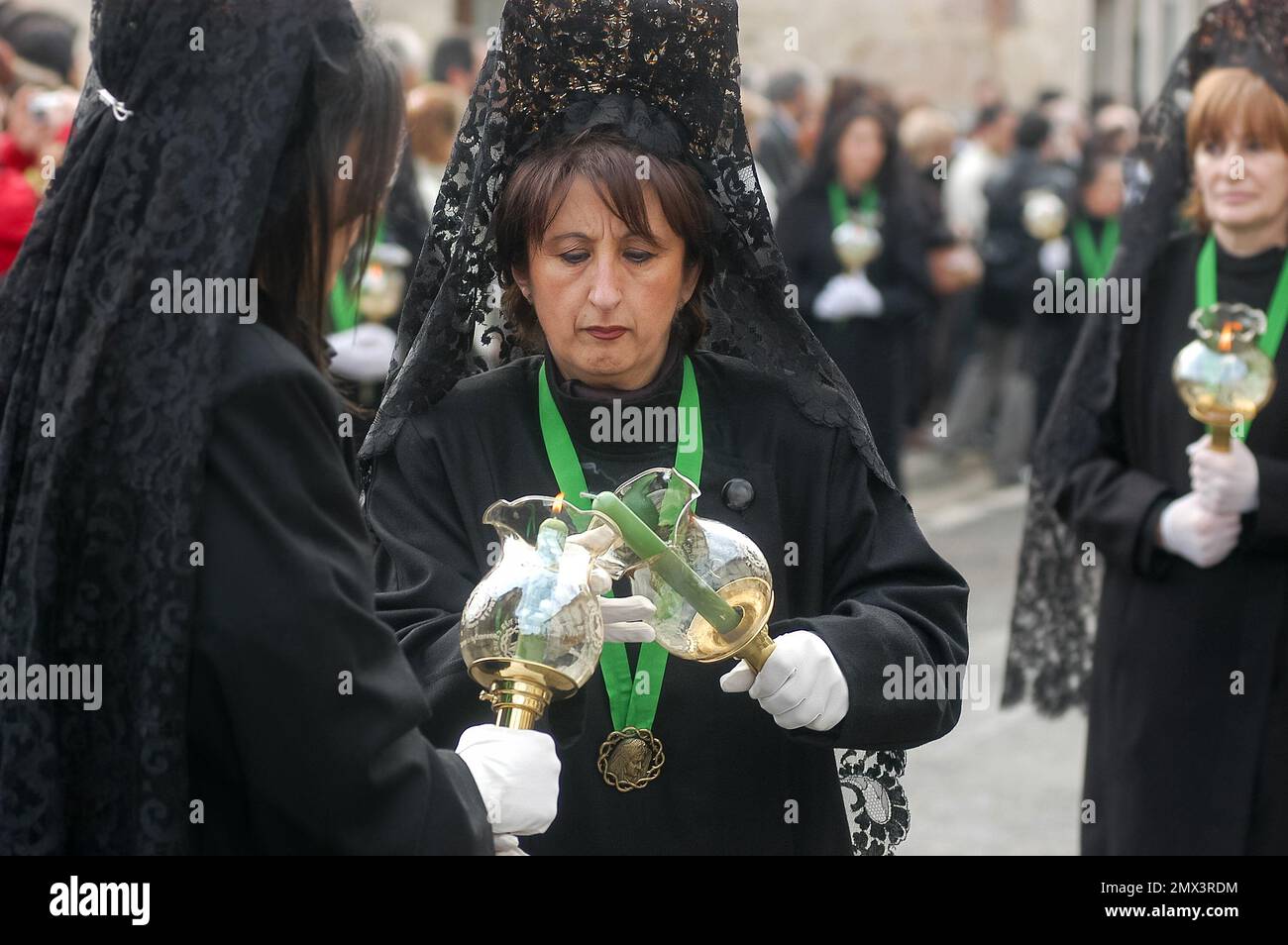 A lady lights her candle in the procession of the Brotherhood of the ...