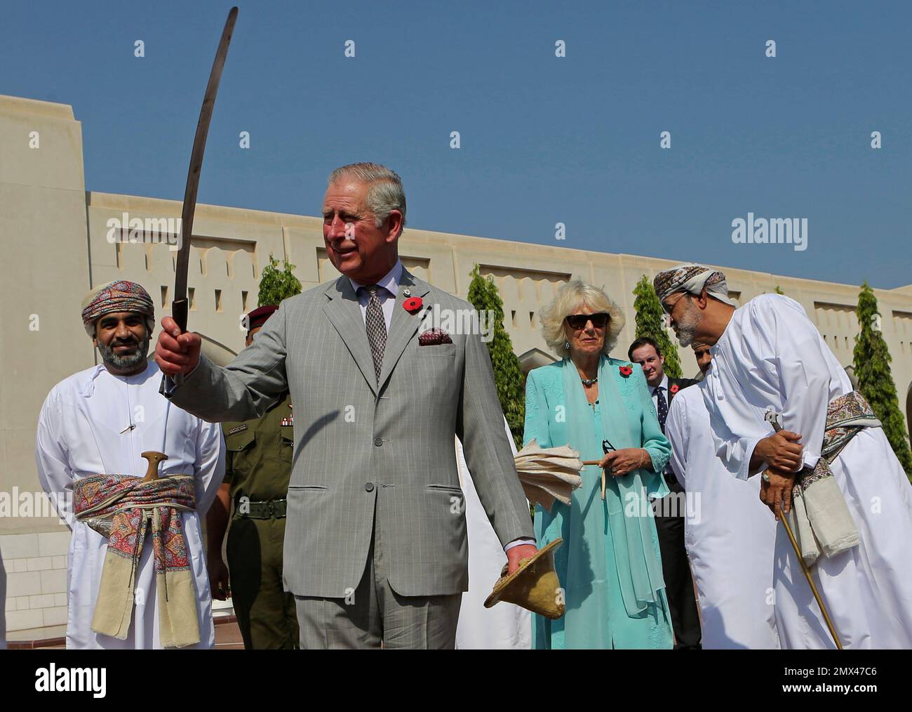 Britain's Prince Charles dances with a sword with a group of Omani ...