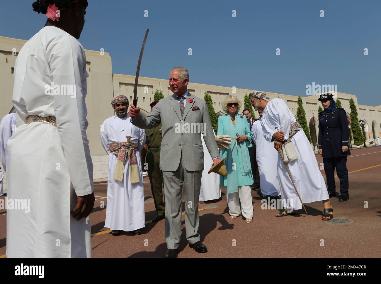 Britain's Prince Charles dances with a sword with a group of Omani ...
