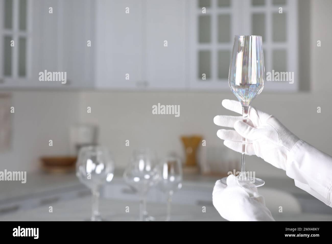 Person in white gloves checking cleanliness of glass indoors, closeup ...