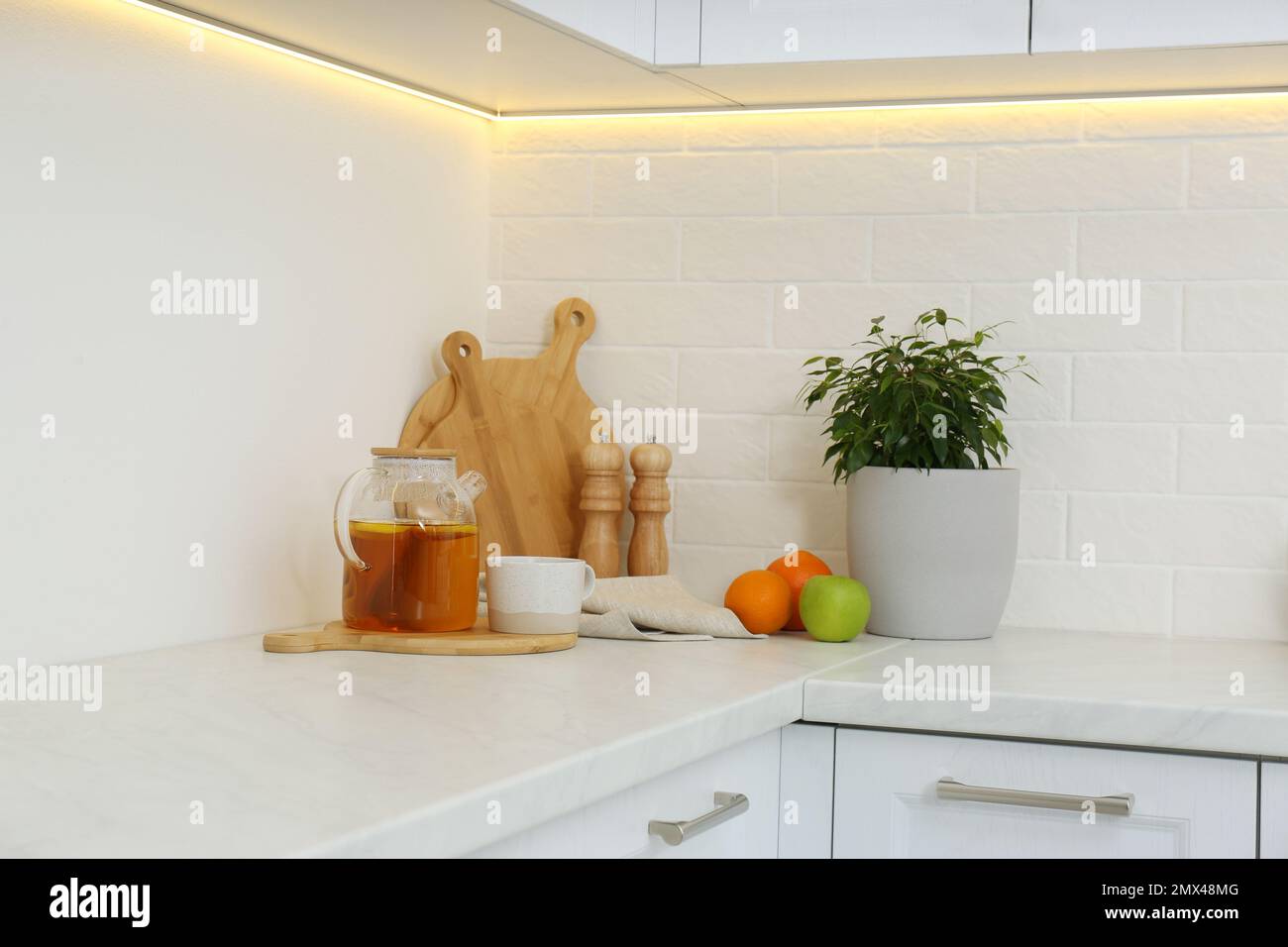 Different kitchen items and houseplant on countertop indoors Stock ...