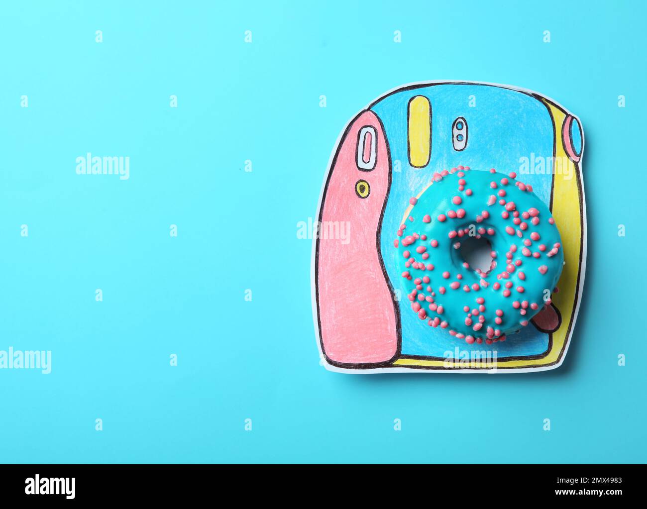 Camera made with donut on light blue background, top view. Space for ...