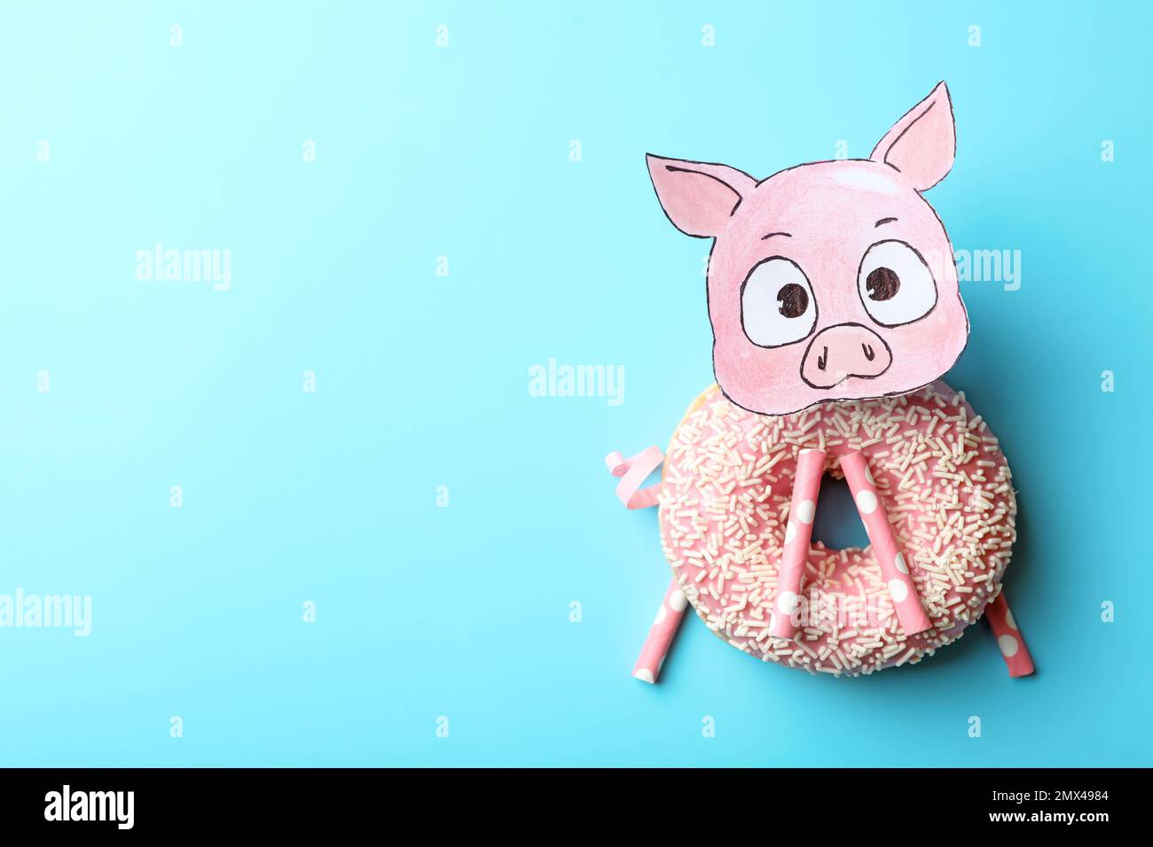 Funny pig made with donut and straws on light blue background, flat lay ...