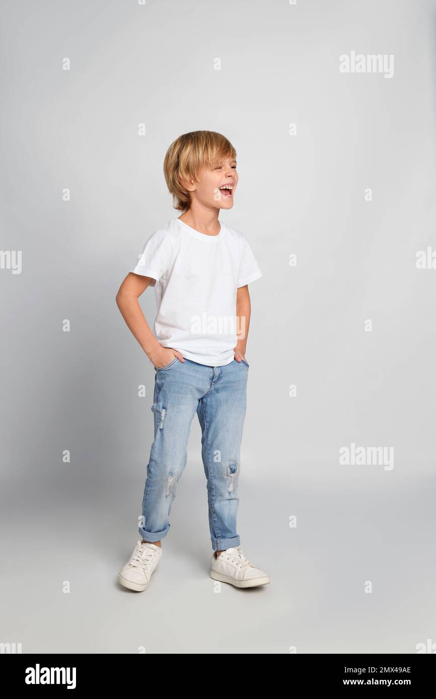 Happy little boy in casual outfit on light grey background Stock Photo ...