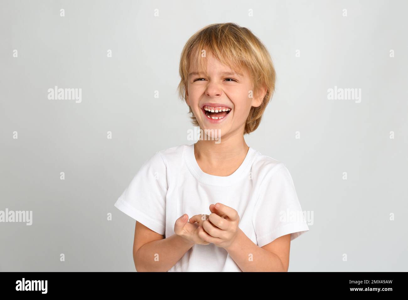Happy little boy on light grey background Stock Photo - Alamy