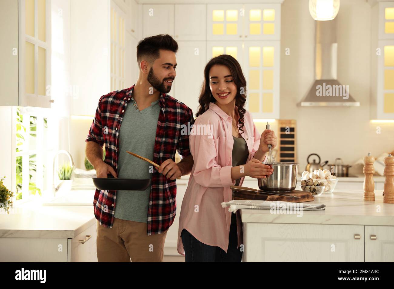 Lovely young couple cooking together in kitchen Stock Photo - Alamy