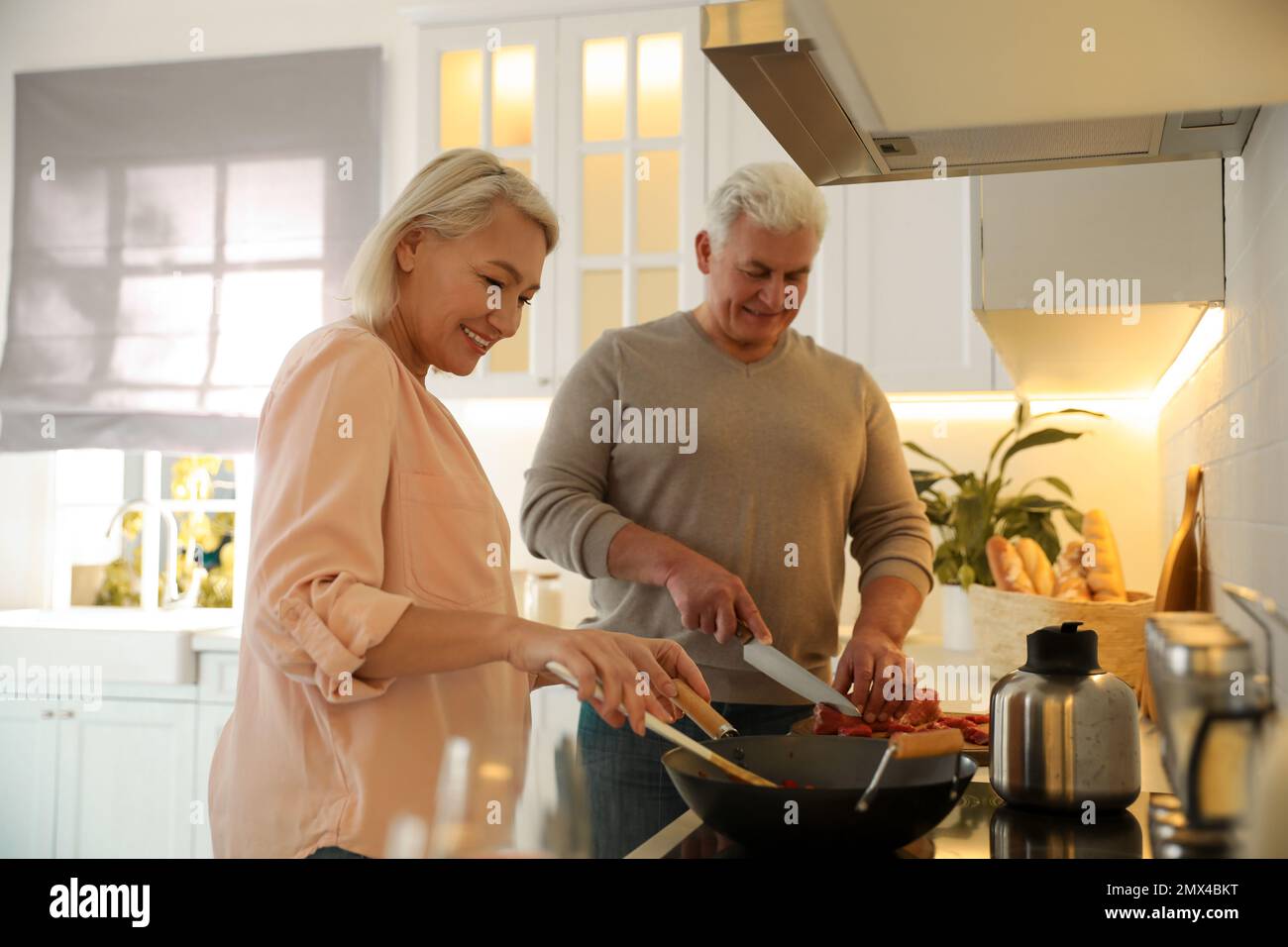 Mature couple cooking food together in kitchen Stock Photo - Alamy