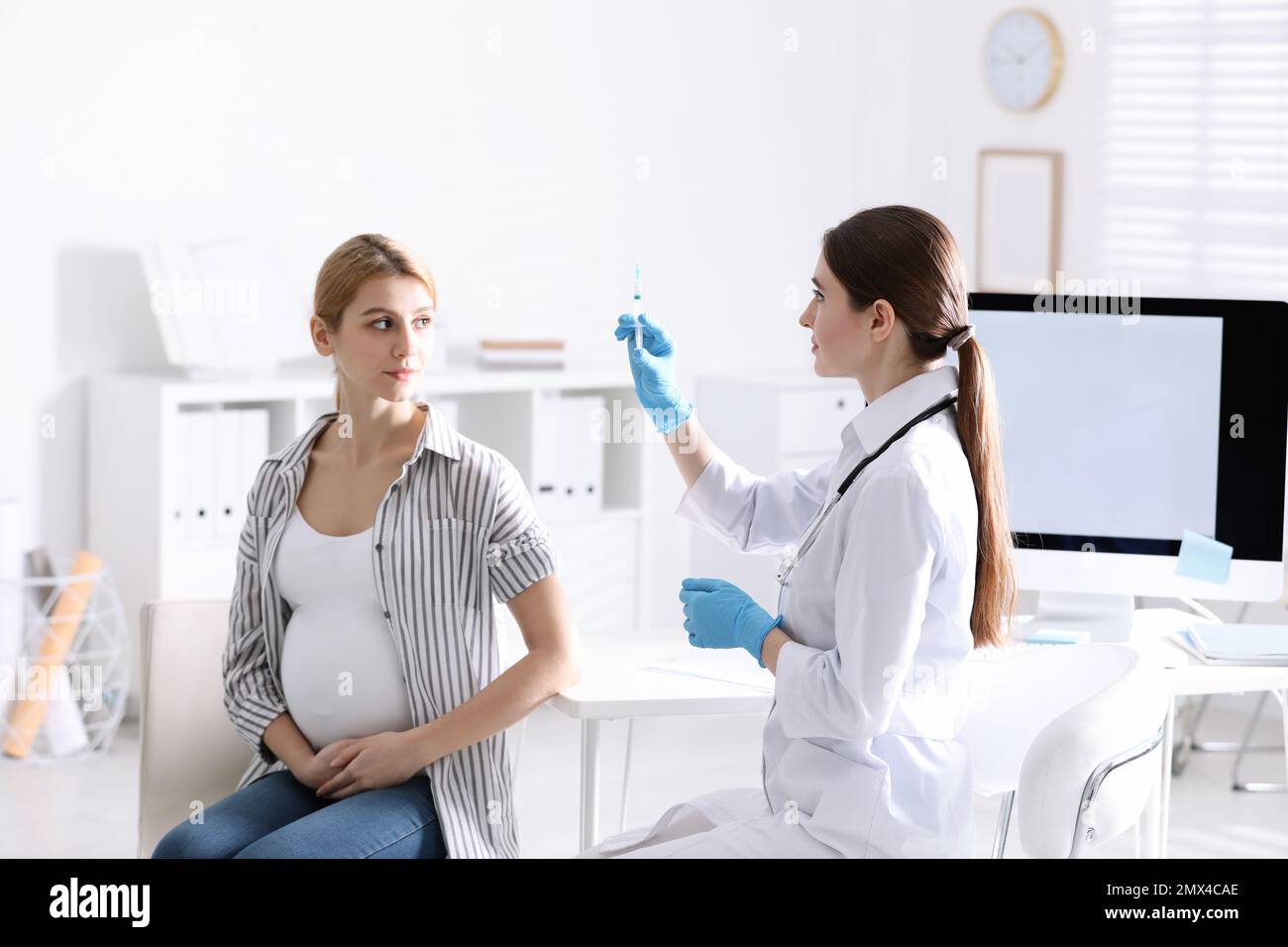 Doctor giving injection to pregnant woman in hospital. Vaccination ...