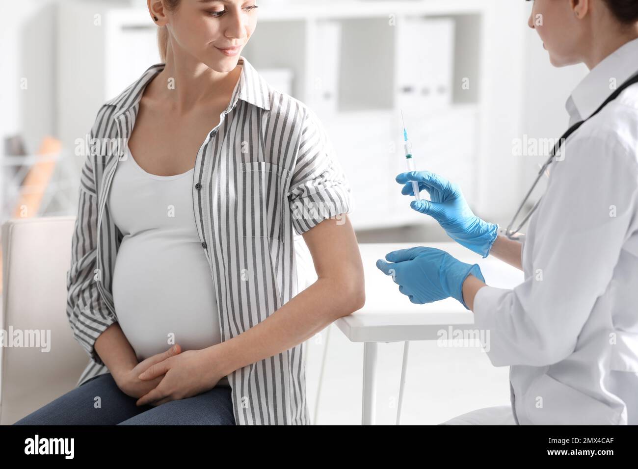 Doctor giving injection to pregnant woman in hospital. Vaccination ...