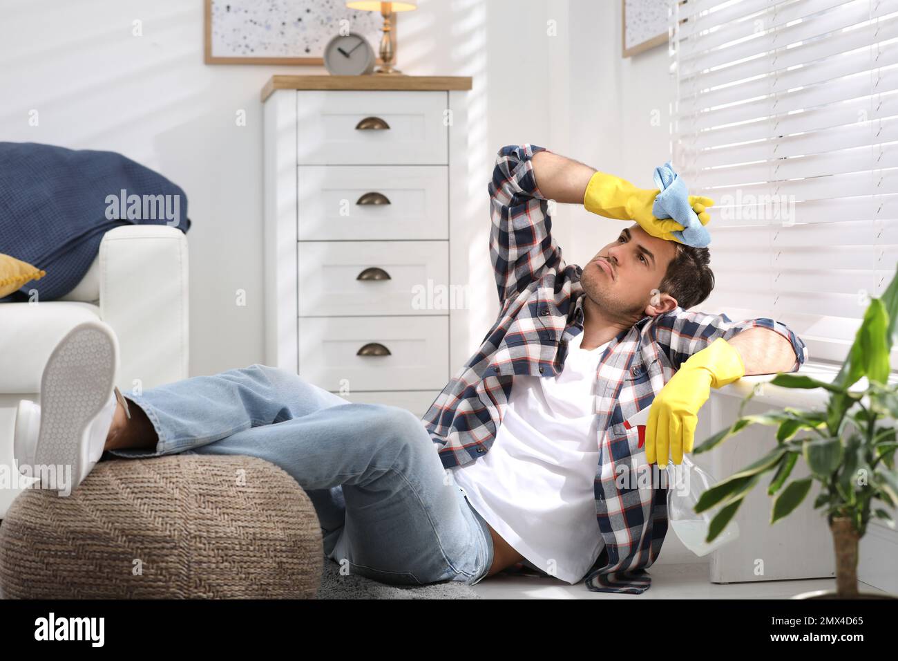 Lazy man procrastinating while cleaning at home Stock Photo - Alamy