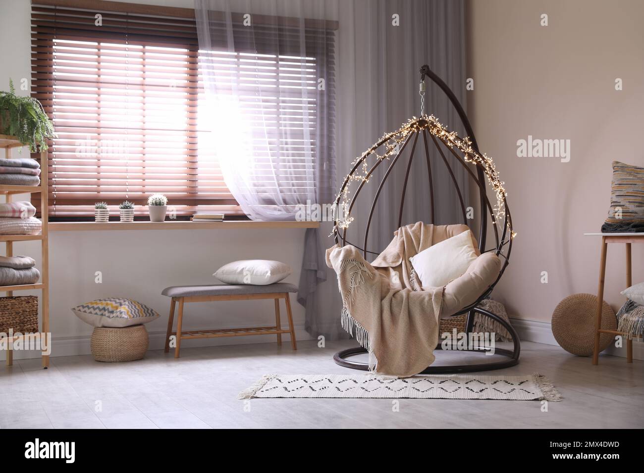 Cozy hanging chair with fairy lights in modern living room. Interior ...