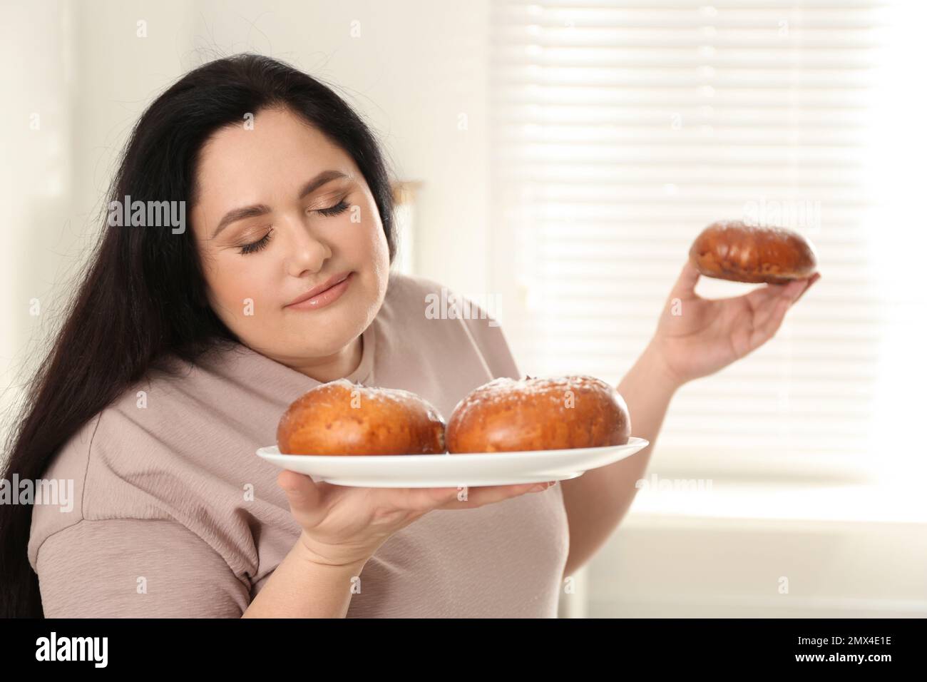 Lazy overweight woman with buns at home Stock Photo - Alamy