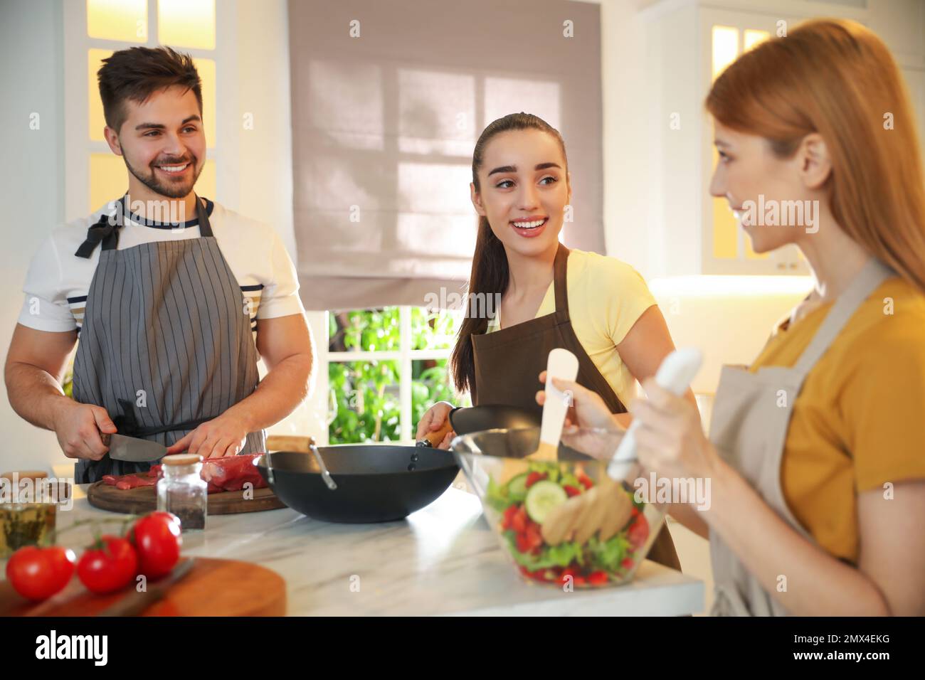 Happy people cooking food together in kitchen Stock Photo - Alamy