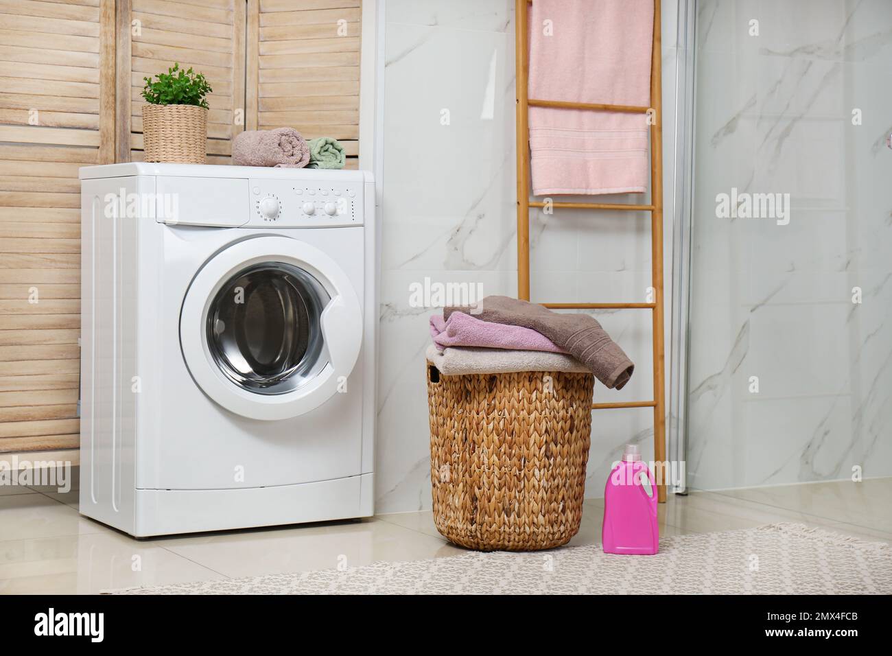 Modern washing machine and laundry in bathroom Stock Photo - Alamy
