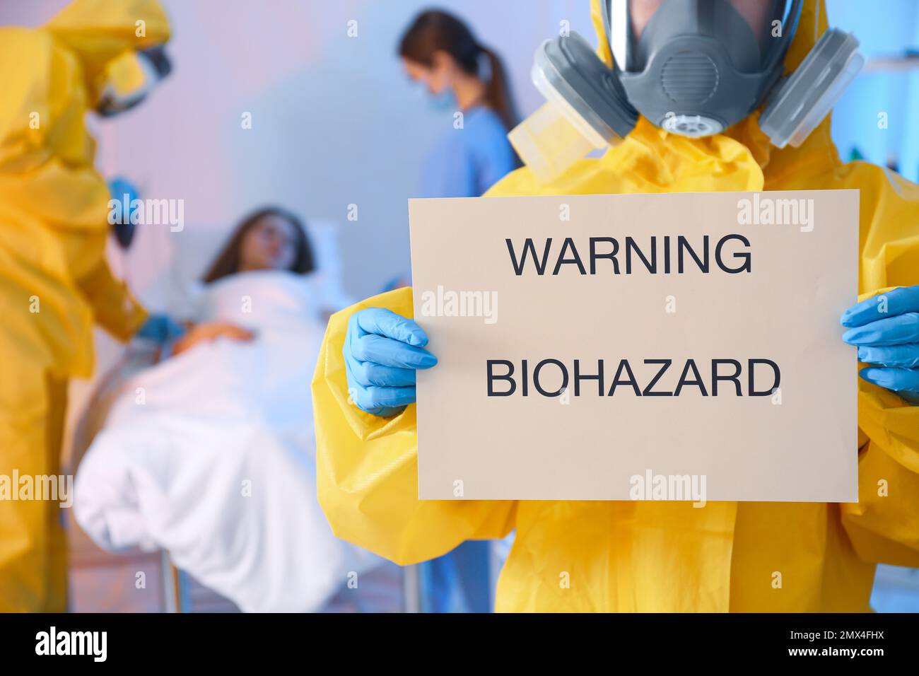 Paramedic holding sign with words WARNING BIOHAZARD in quarantine ward ...