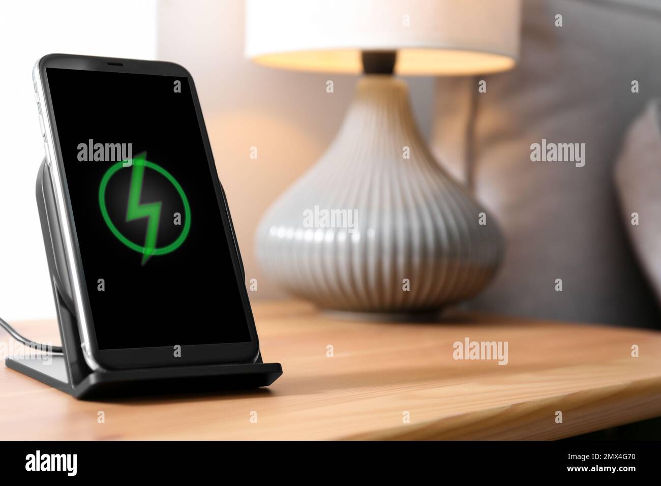 Smartphone charging on wireless pad in room. Space for text Stock Photo ...