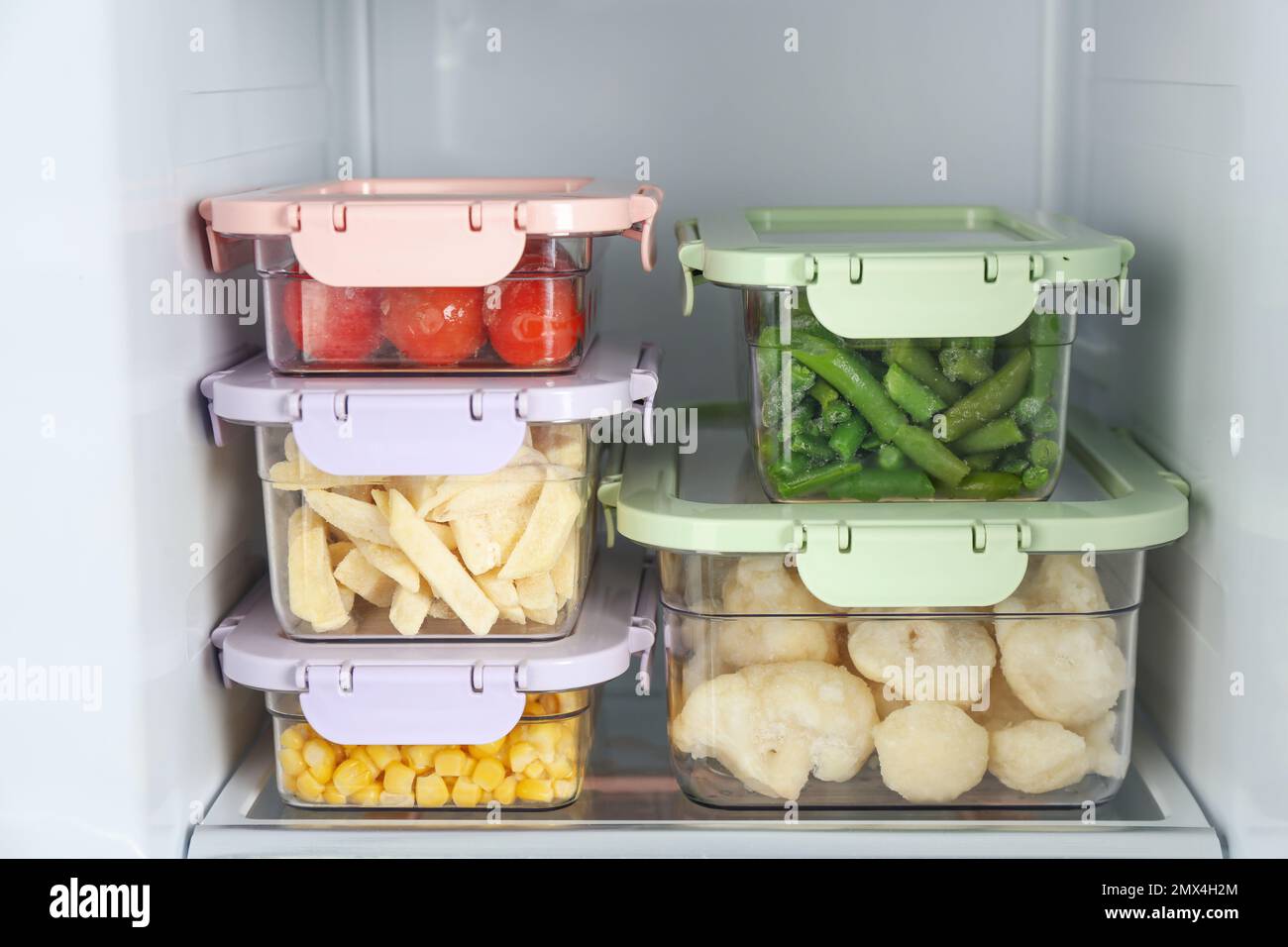Containers with different frozen vegetables in refrigerator Stock Photo ...