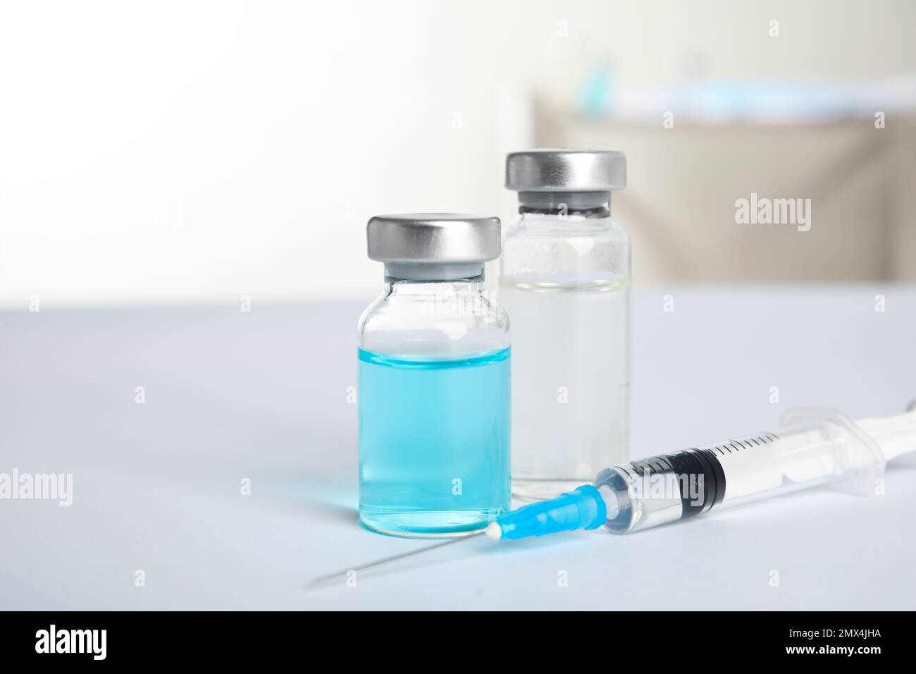 Vials and syringe on light background. Vaccination and immunization ...