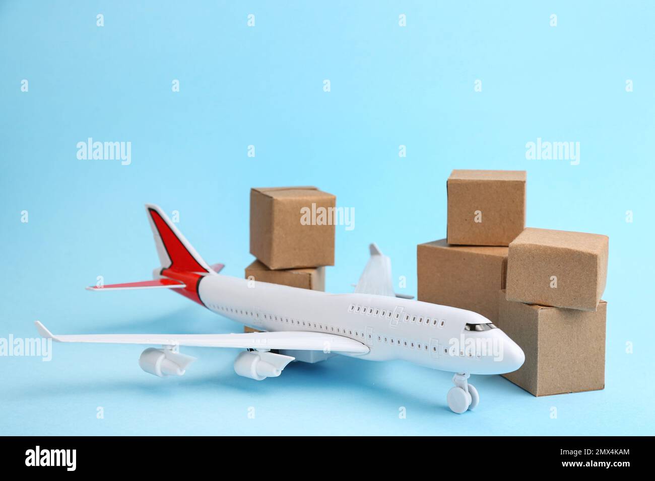 Airplane model and carton boxes on light blue background. Courier ...