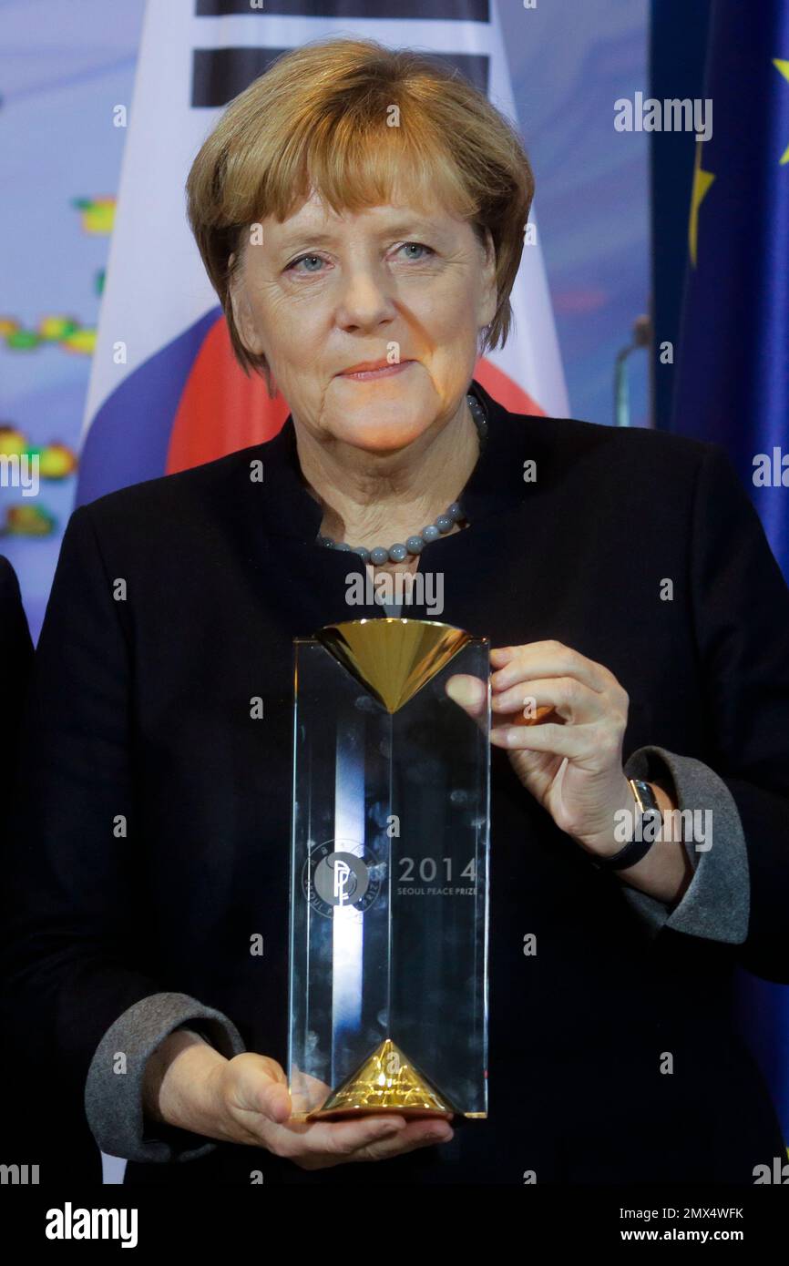 German Chancellor Angela Merkel, right, shows the Seoul Peace Prize ...