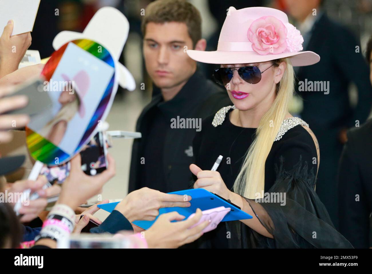 Lady Gaga gives her autographs to fans upon her arrival at Narita ...