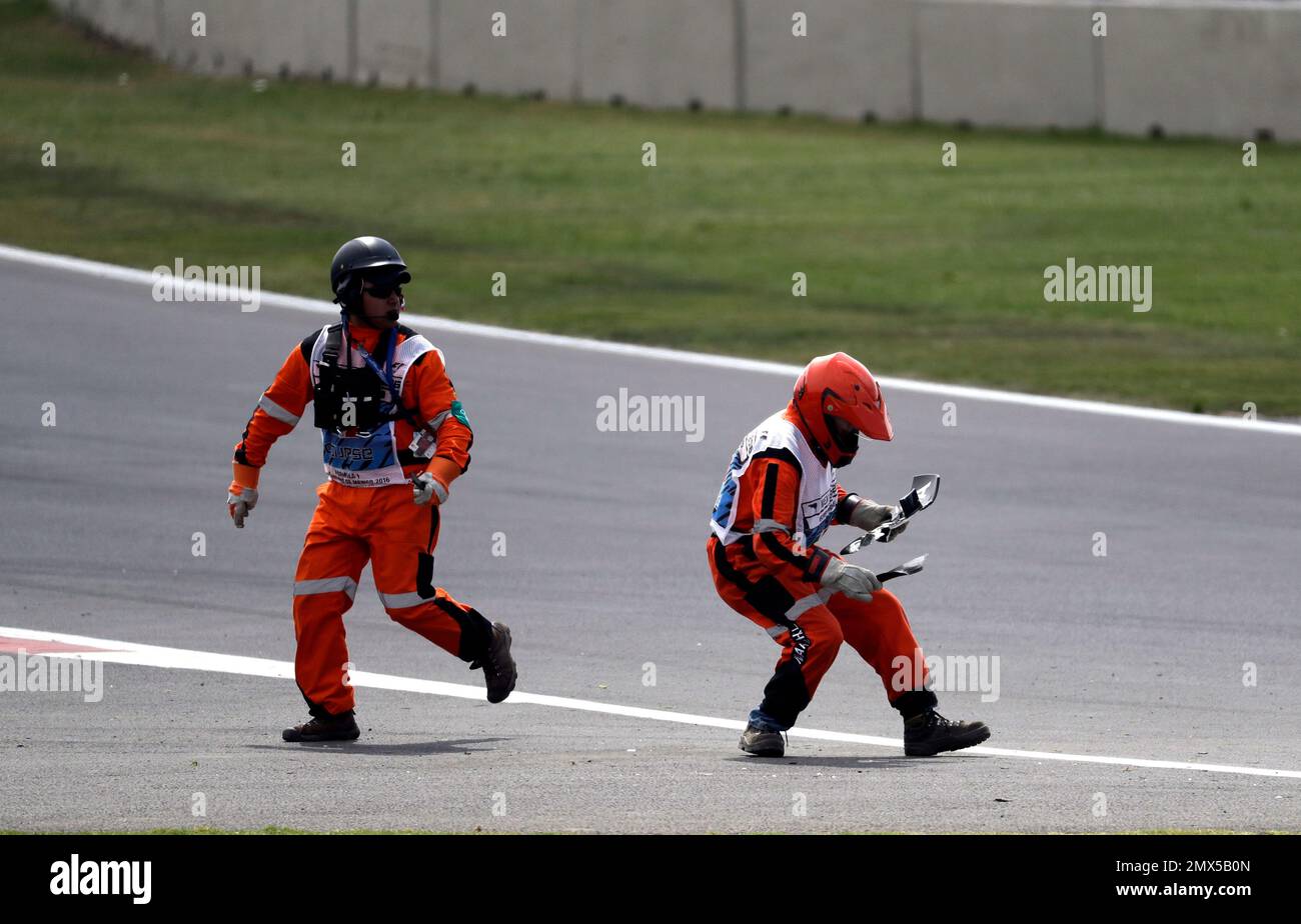 Race track crew collect debris after a crash during the Formula One ...