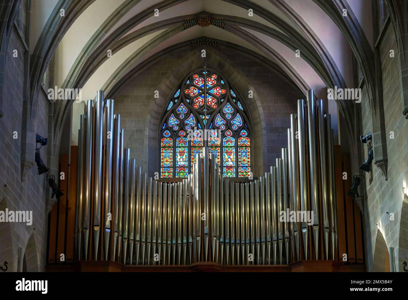 Beautiful old church organ in front of a stained glass window and ...