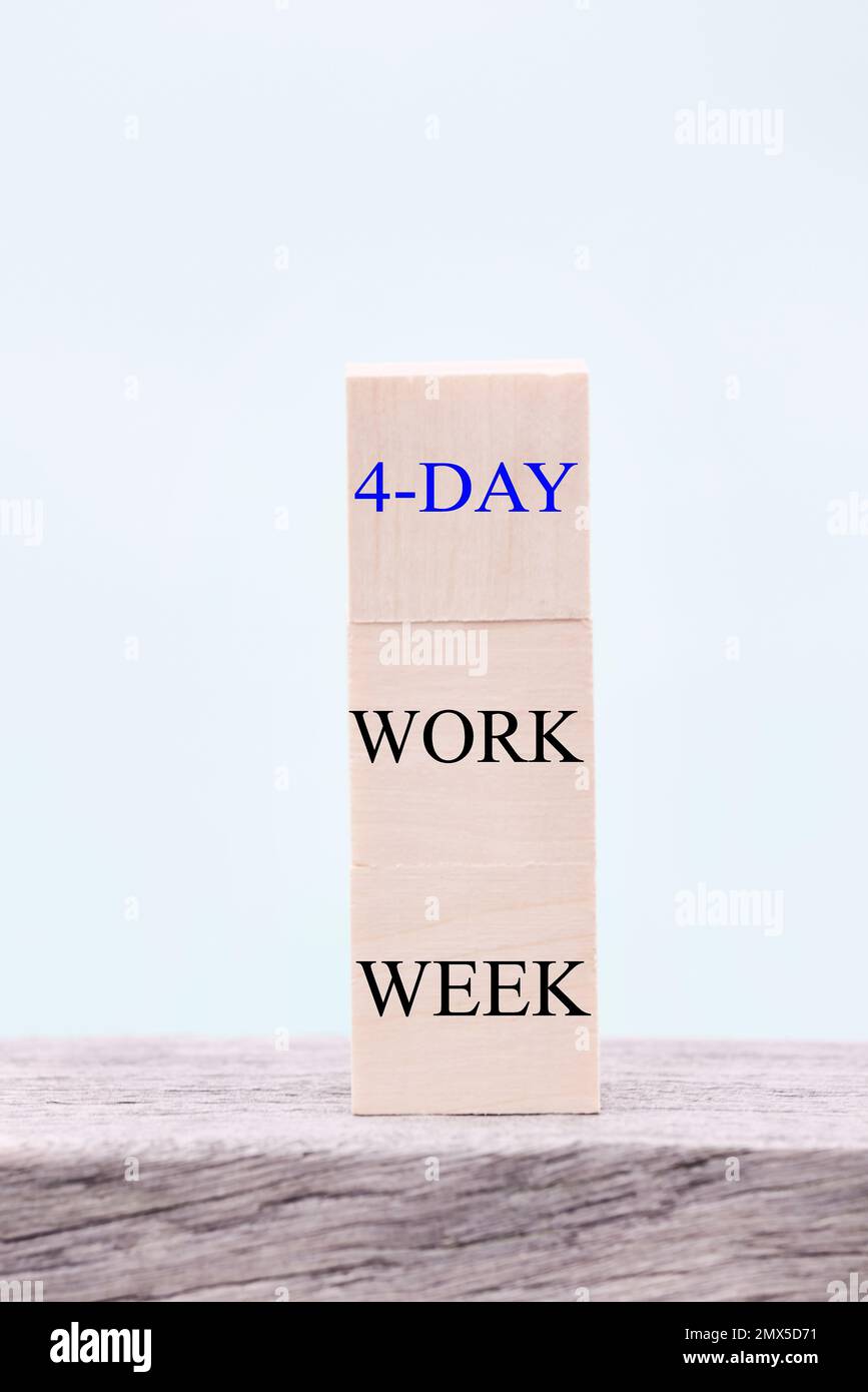 4 day working week words on wooden cube on blue background. reducing ...