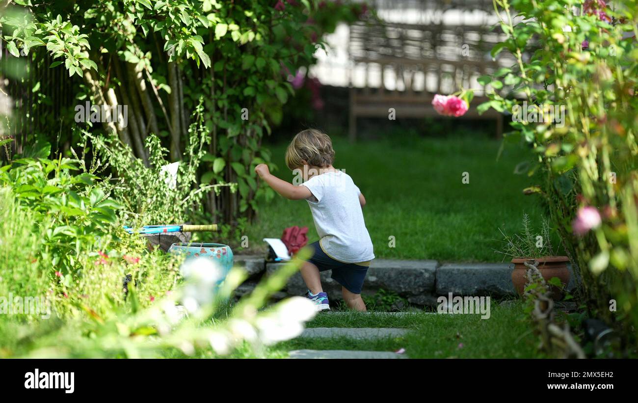 One candid little boy exploring house backyard garden Stock Photo - Alamy