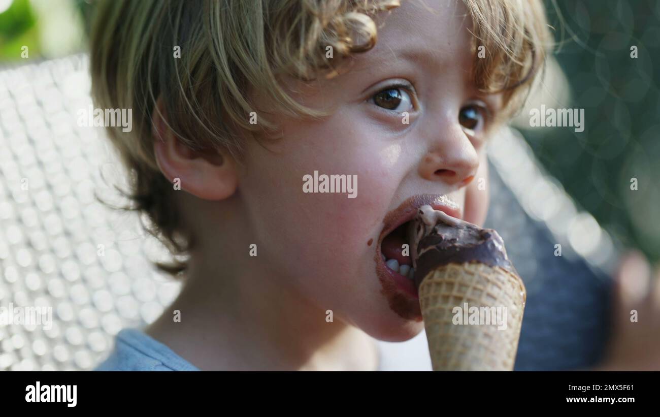 Cute little boy eating ice cream. Male child eats chocolate icecream ...