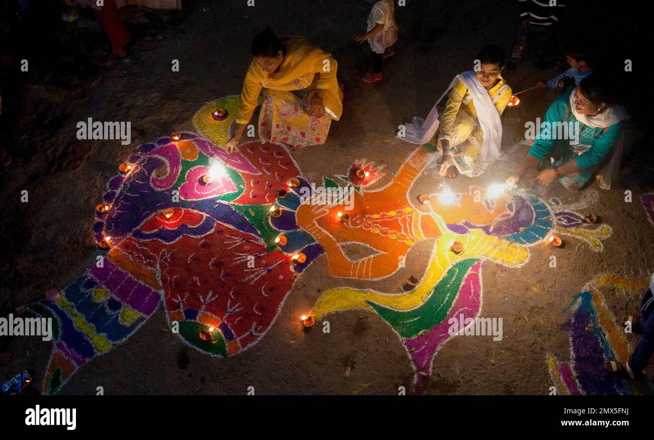 A family from the Hindu community light fireworks as they sit next to a ...