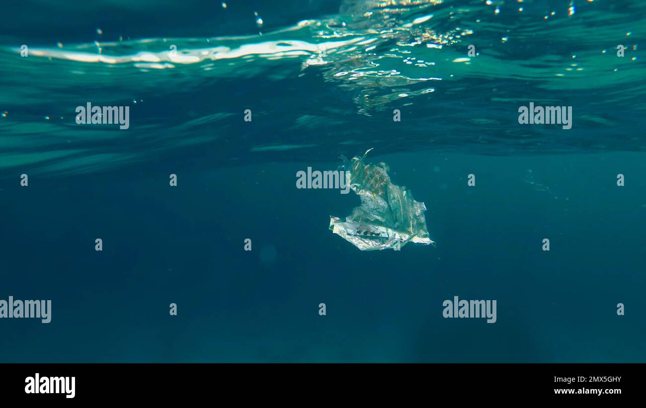 close-up of a plastic bag floating in the sea. Garbage in the sea water ...