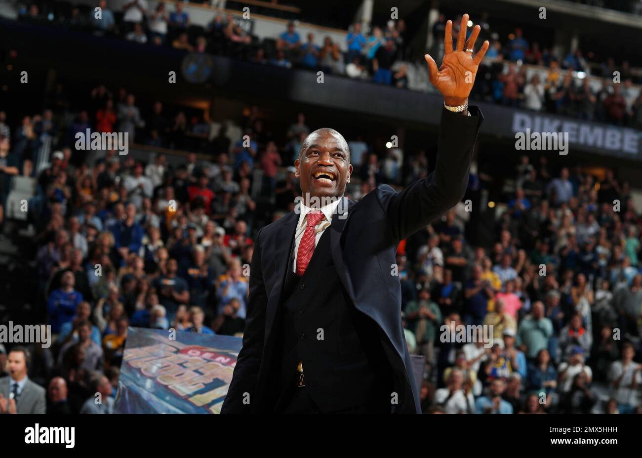 Retired Denver Nuggets center Dikembe Mutombo waves to the crowd as his ...