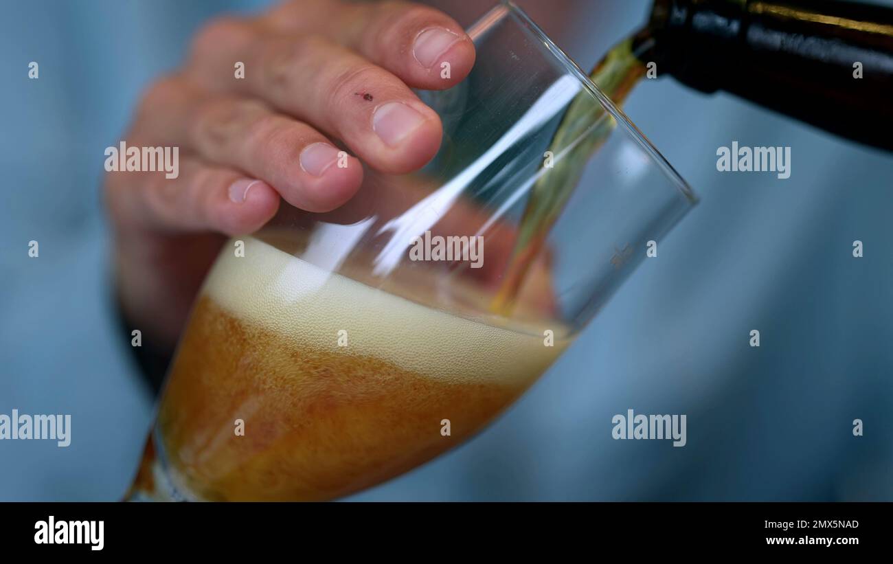 Pouring beer into glass closeup in slow motion. Closeup hand serving beer into glass Stock Photo ...