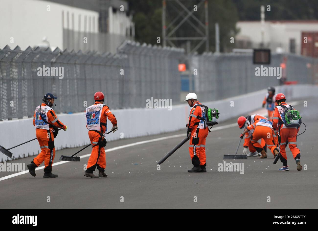 Track marshals clear debris from the track after Sauber driver Felipe ...