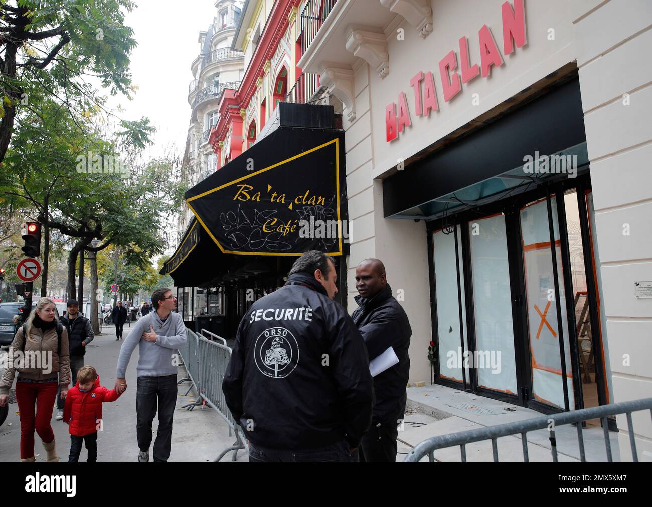 A family walks past the renovated facade of the Bataclan concert hall ...