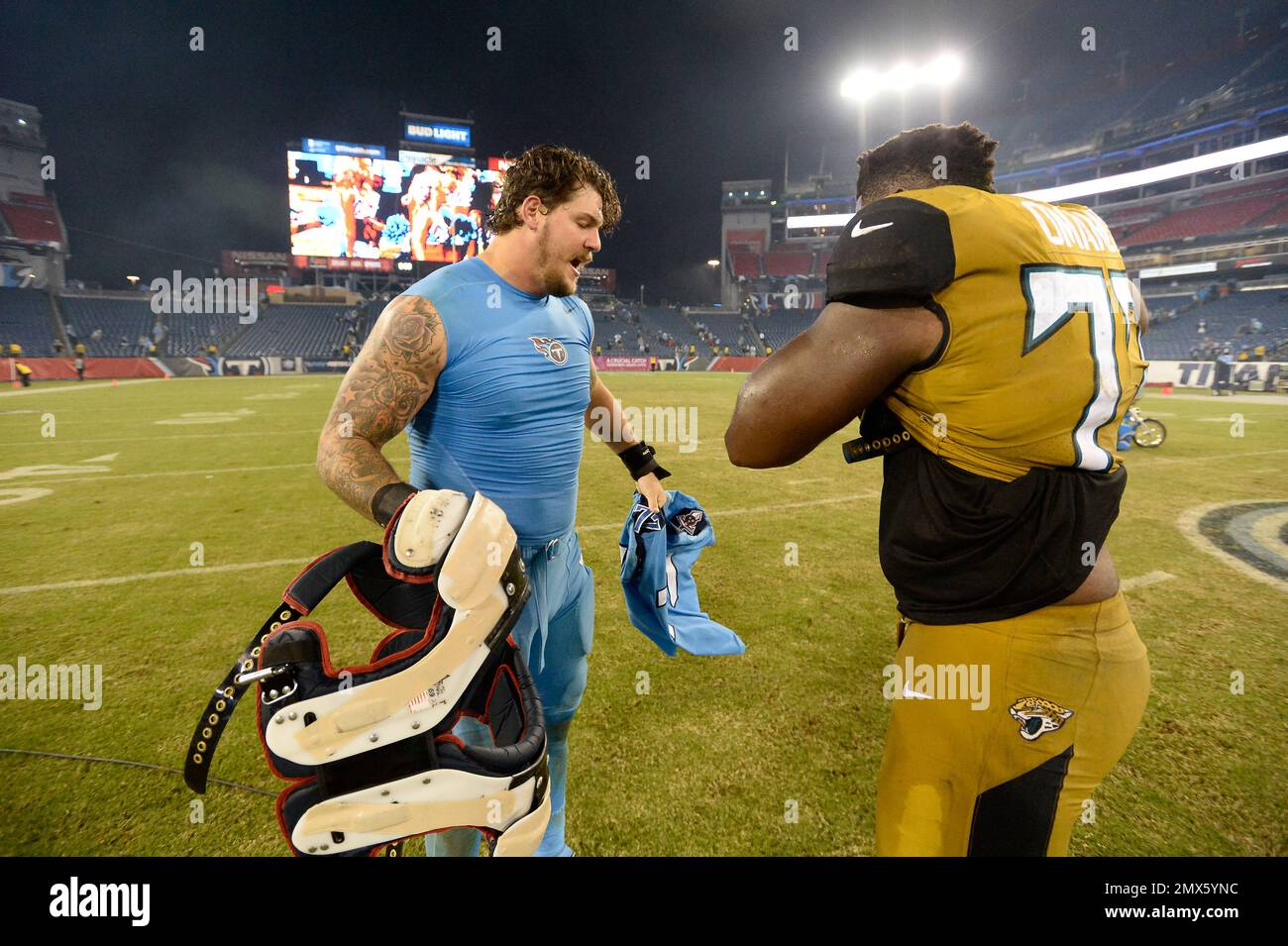 Tennessee Titans tackle Taylor Lewan, left, trades jerseys with ...