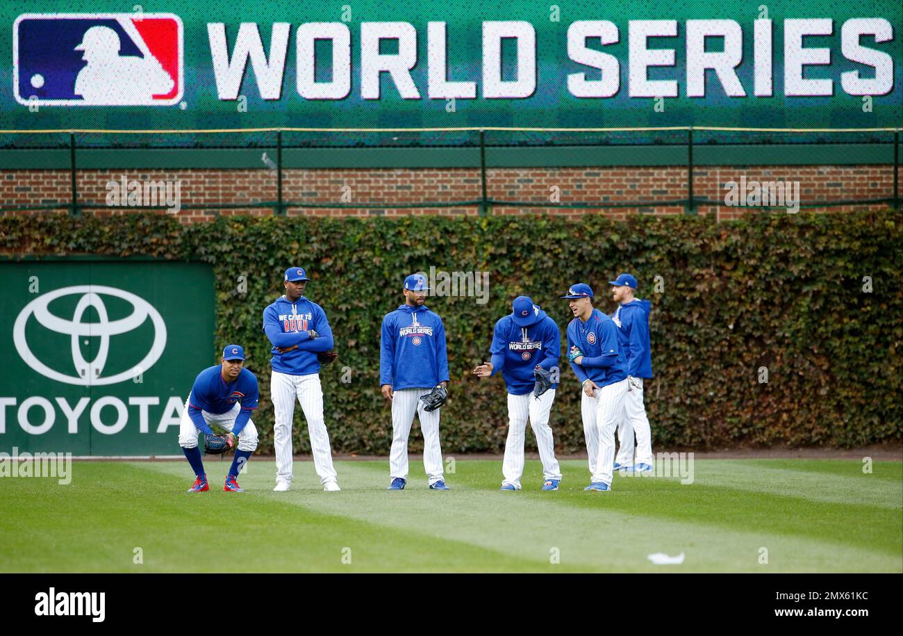 Chicago Cubs players work out in the outfield during batting practice ...