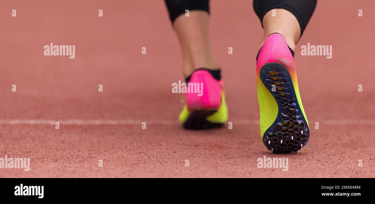 Female athlete running on stadium track, dynamic run of sprinter in a ...