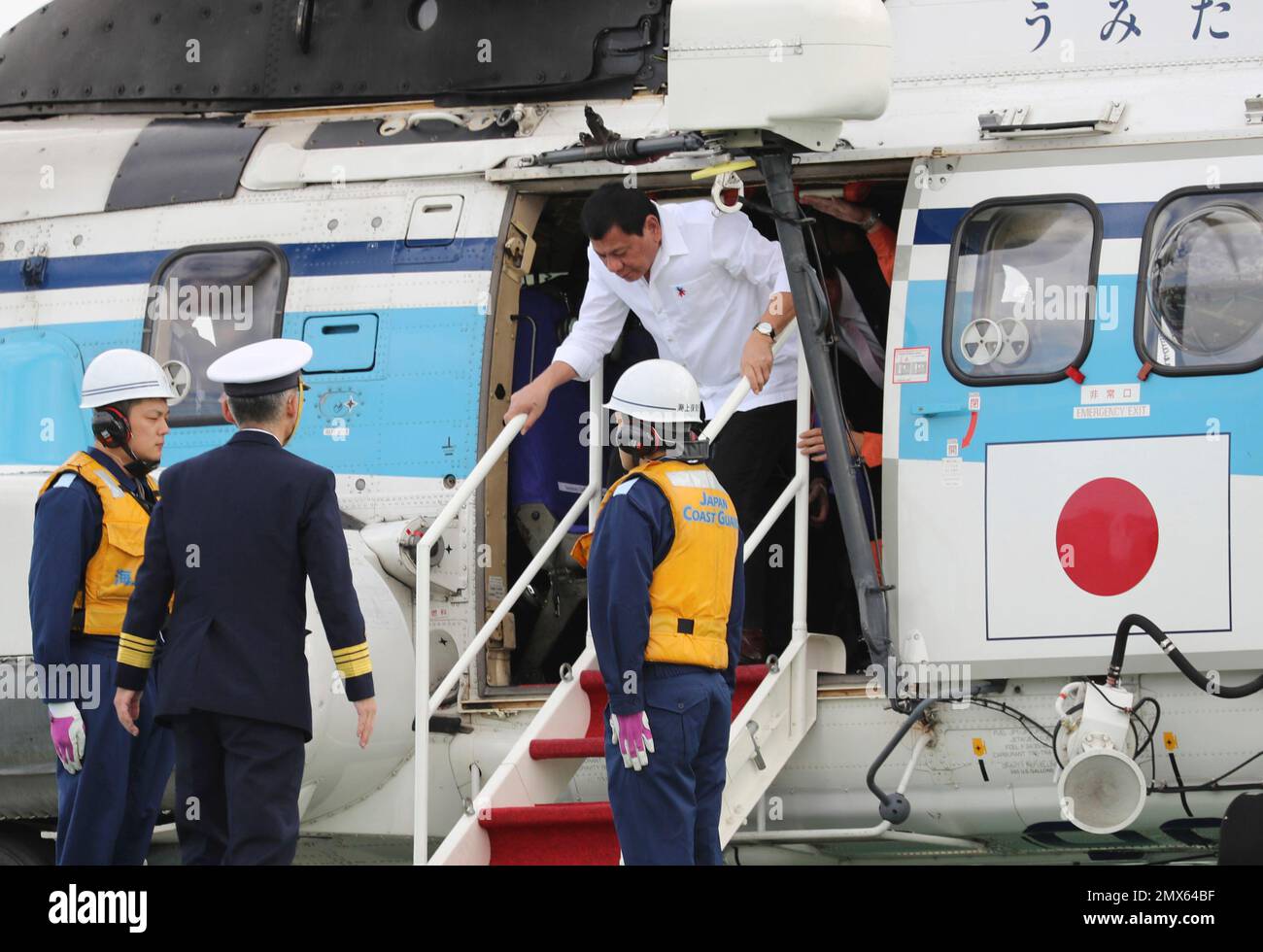 Philippine President Rodrigo Duterte, center in white outfit, gets off ...