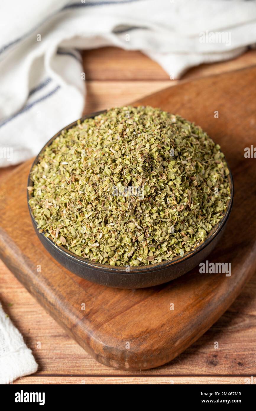 Dried thyme leaves. Thyme spice in a bowl on a wooden background. Dry ...