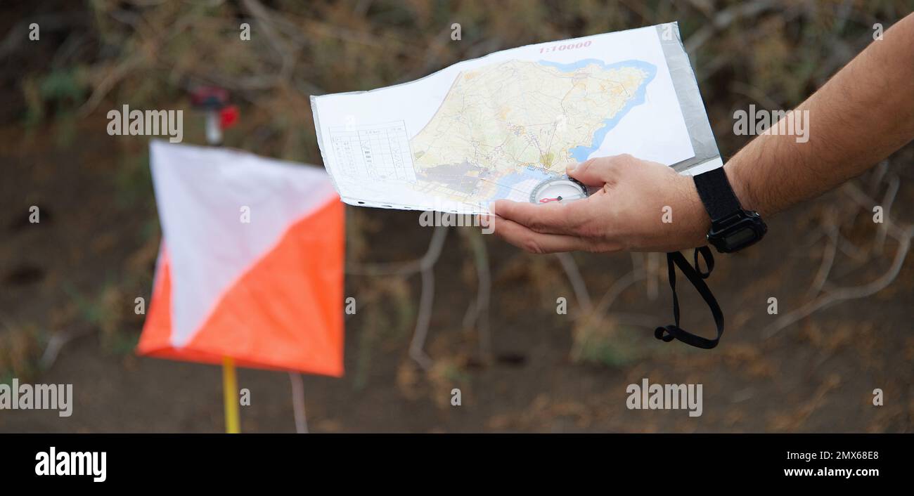 Man holding map.Athlete uses navigation equipment for orienteering ...