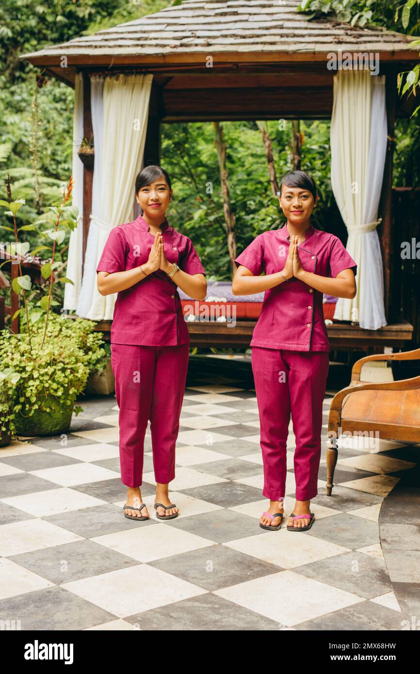 Vertical shot of two women massage therapist welcoming guest at spa ...