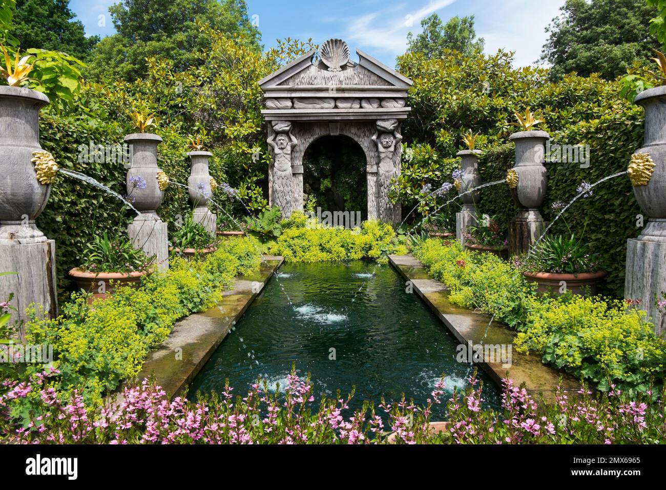 A pool with Alchemilla Mollis and a shell grotto pavillionand water ...