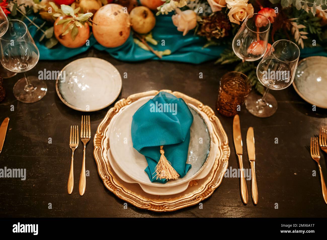 Exquisite, elegant golden and blue table set decoration in moody dark ...