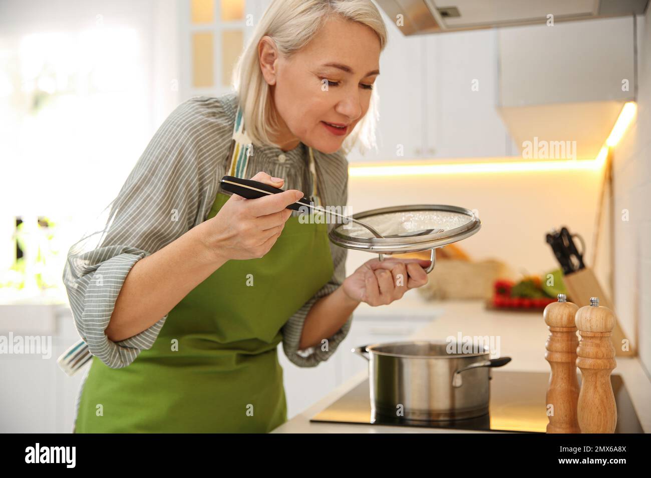 Woman cooking at stove hi-res stock photography and images - Alamy